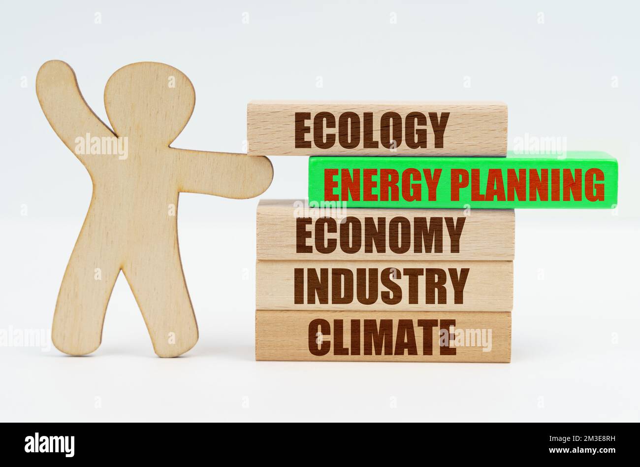 Ecology and industry concept. The wooden man moves the green block with ...