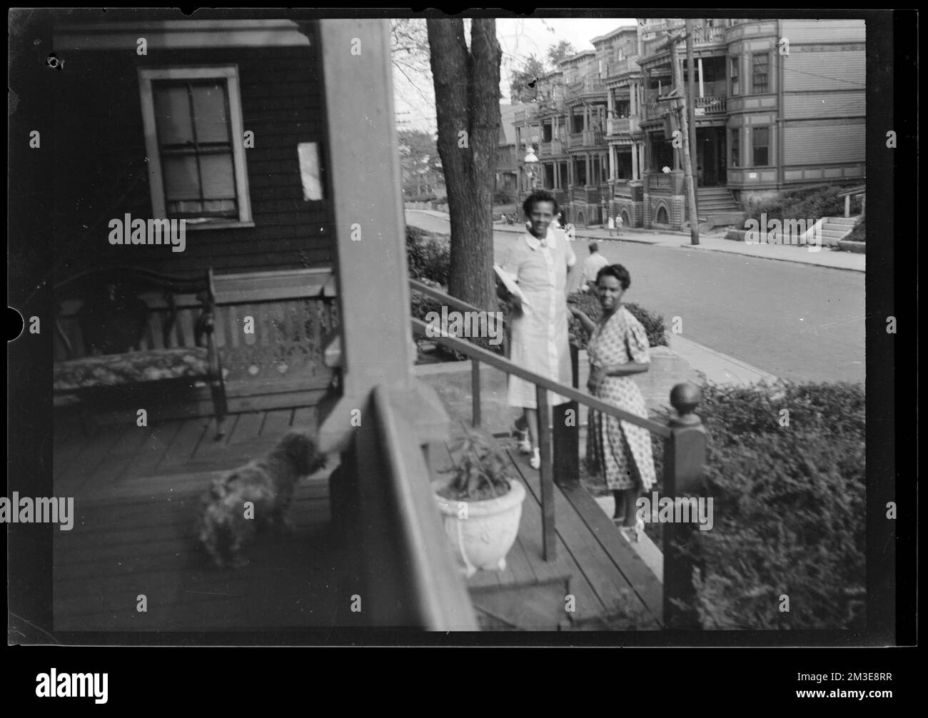 Lottie Miller and another woman on steps, dog in the foreground ...
