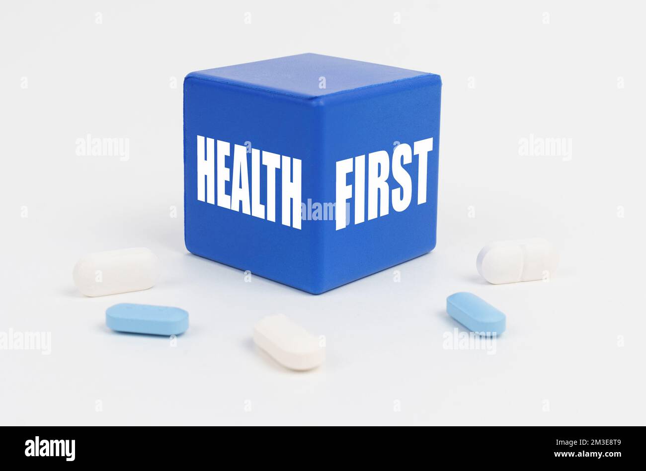 Medicine and health concept. On a white surface are pills and a blue ...