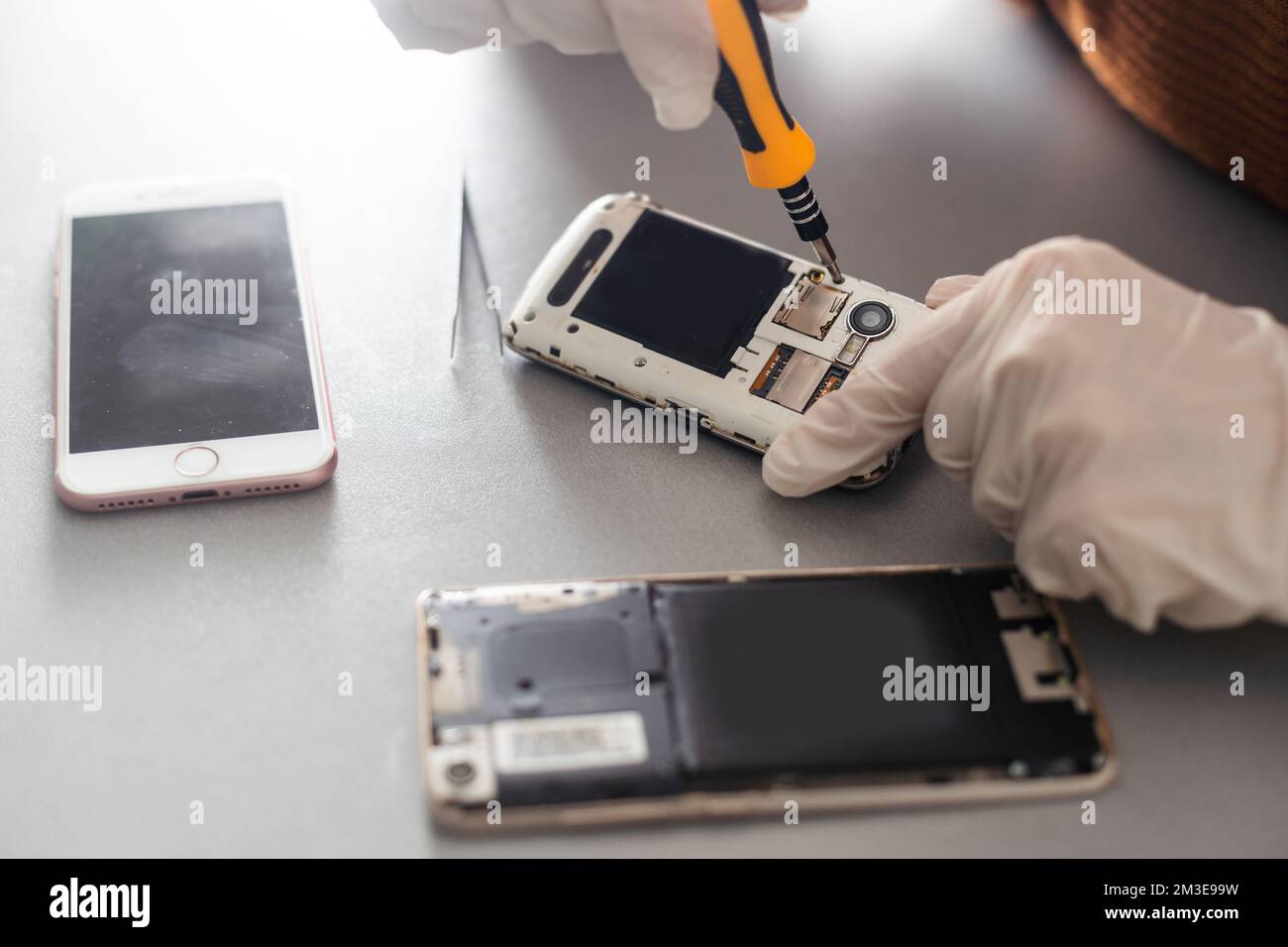 The technician repairing the smartphone's motherboard in the lab with ...
