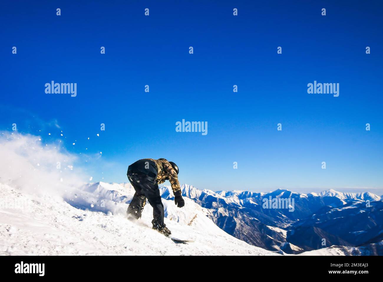 Dynamic picture snowboarder on the piste in caucasus mountains at fast ...