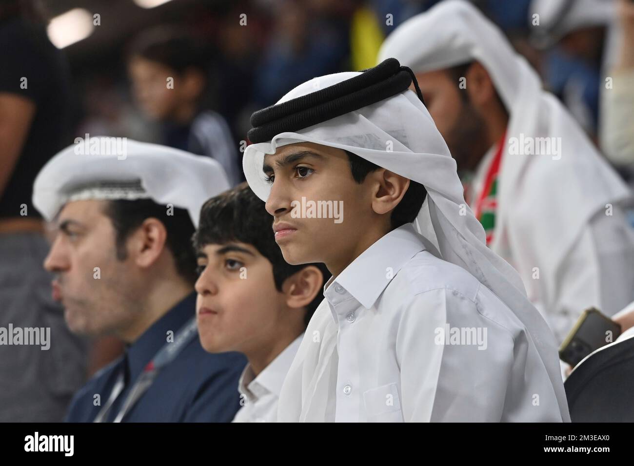 Qatari boys in traditional robes in the stands, fans, football fans ...