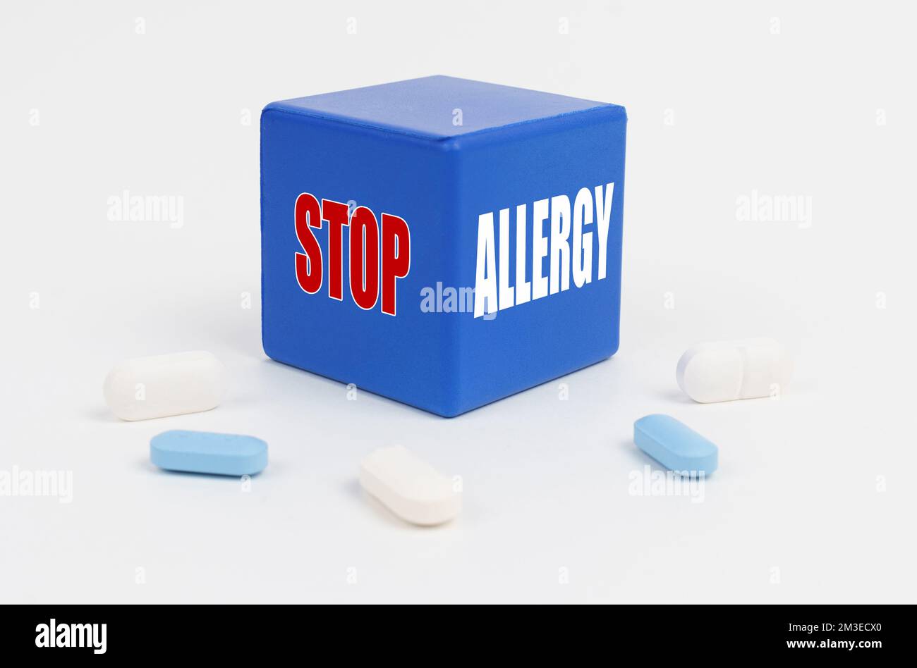 Medicine and health concept. On a white surface are pills and a blue ...