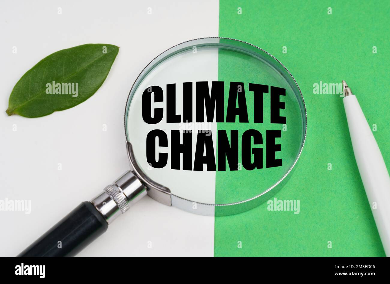 Ecological concept. On a white-green background lies a pen, a leaf of a ...