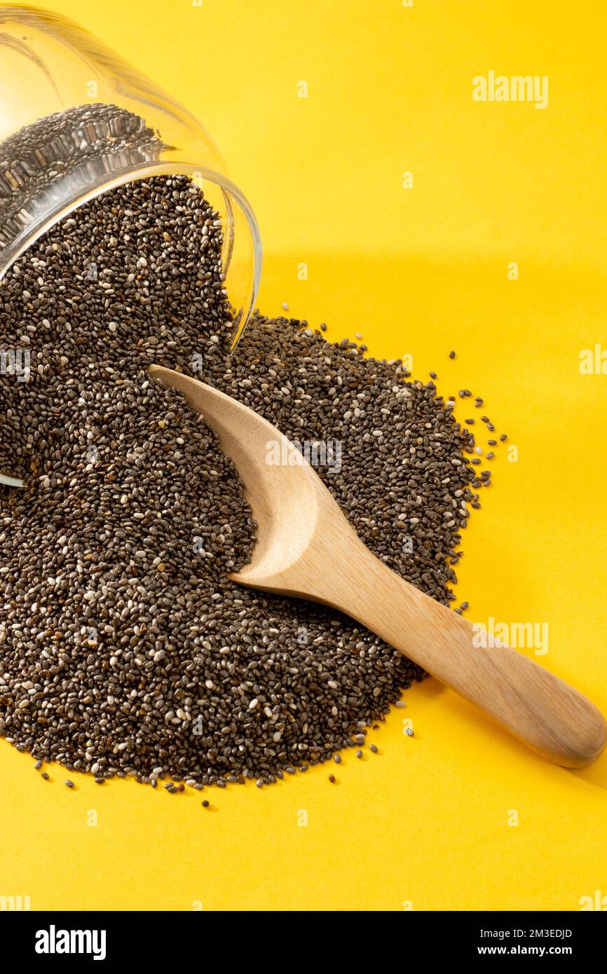 Healthy breakfast, Chia seeds are pouring out from glass jar with wood ...