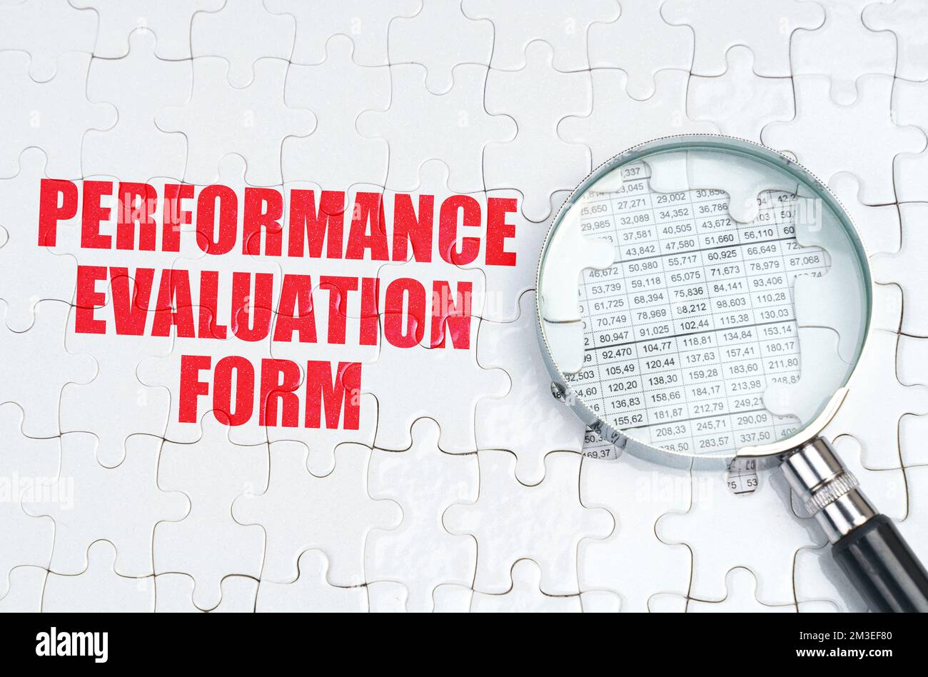 Business concept. There is a magnifying glass on the puzzles, next to ...