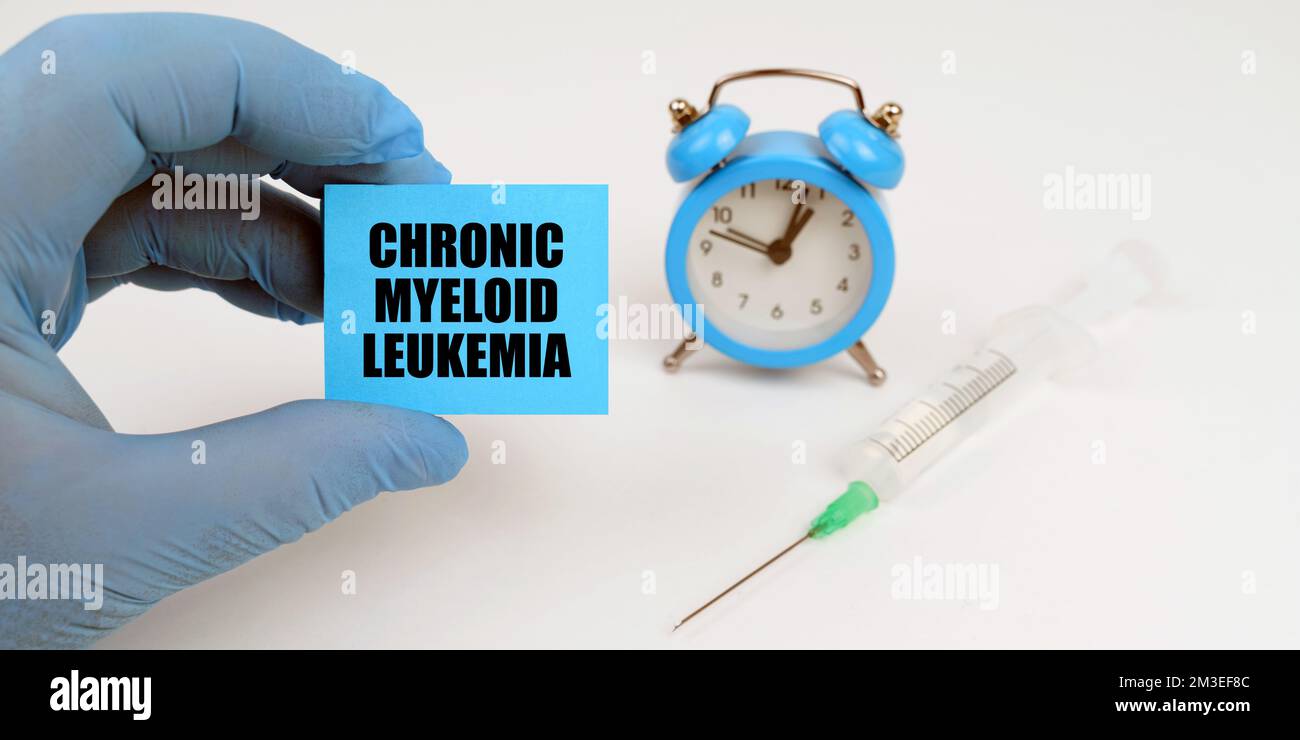 Medicine concept. On the table is a syringe and an alarm clock, in his ...