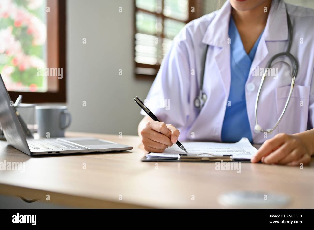 cropped image. Smart millennial Asian female doctor taking notes or ...