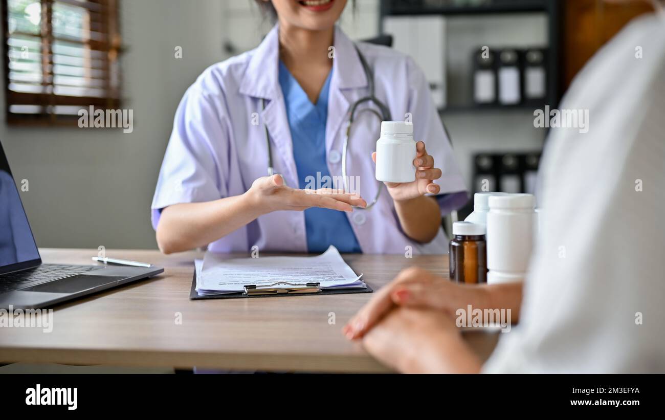 A professional Asian female doctor explaining and giving medicine ...