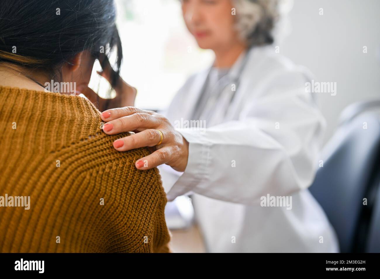 Professional Asian female doctor touching shoulder to comfort and ...