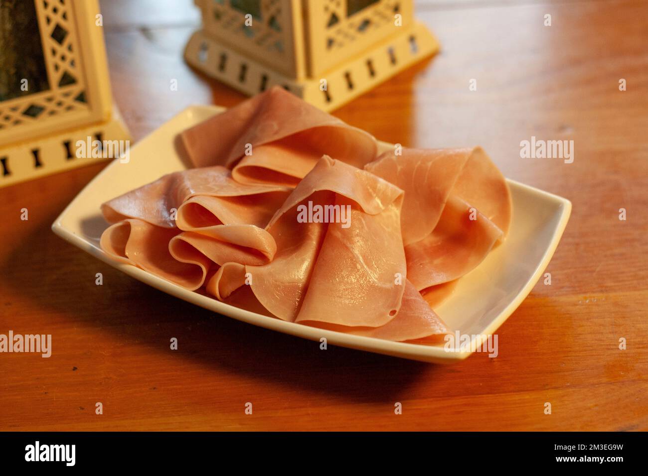 thin slices of York ham on a small white tray with small mint leaves to ...