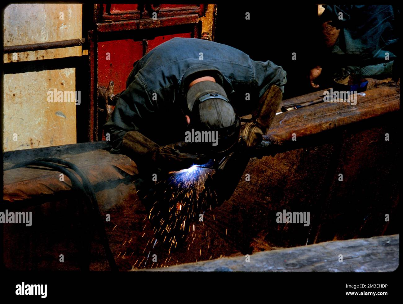 Man leaning over to weld , Welding. Edmund L. Mitchell Collection Stock ...