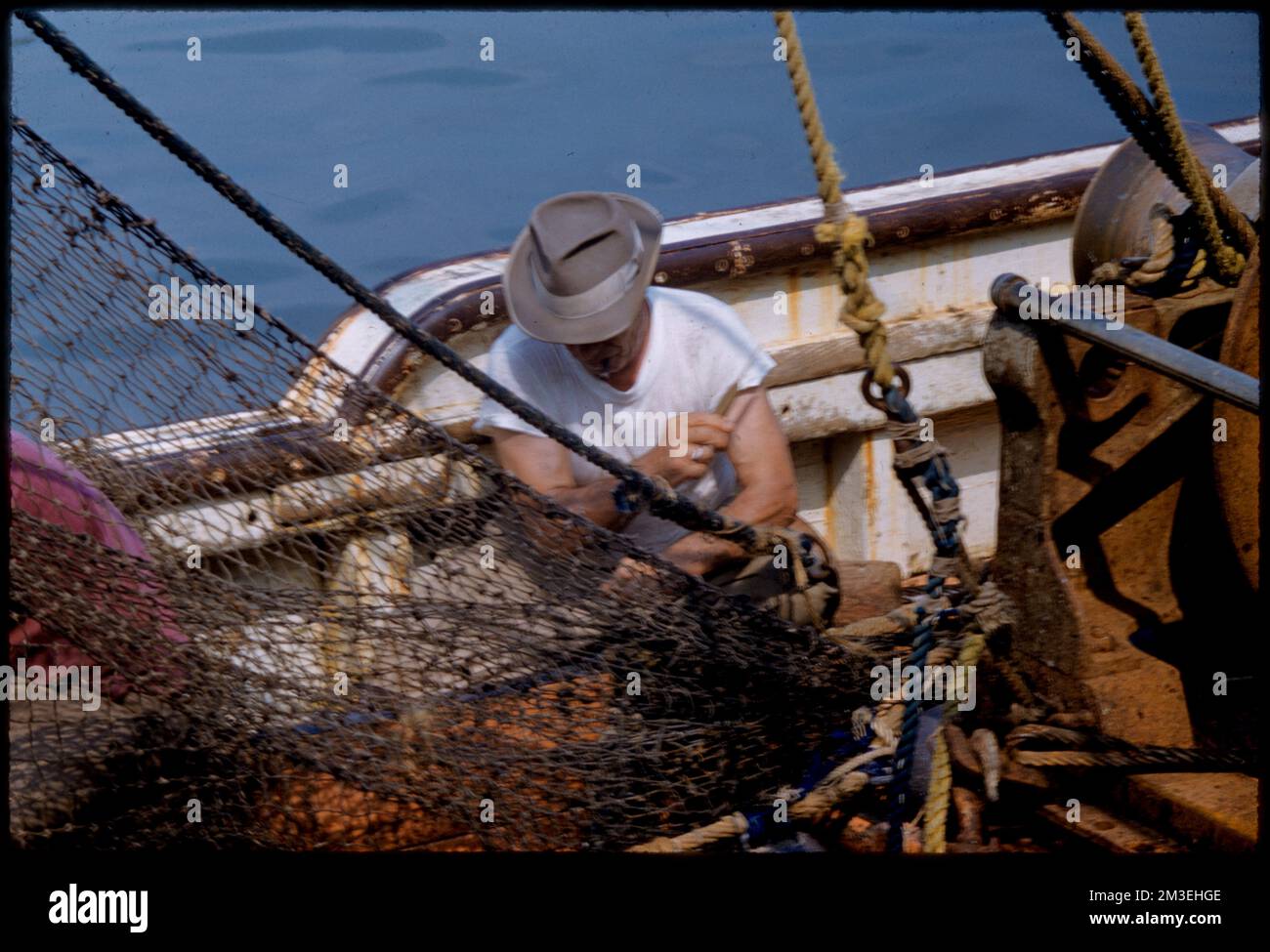 Man on boat working with net , Ship equipment & rigging. Edmund L ...