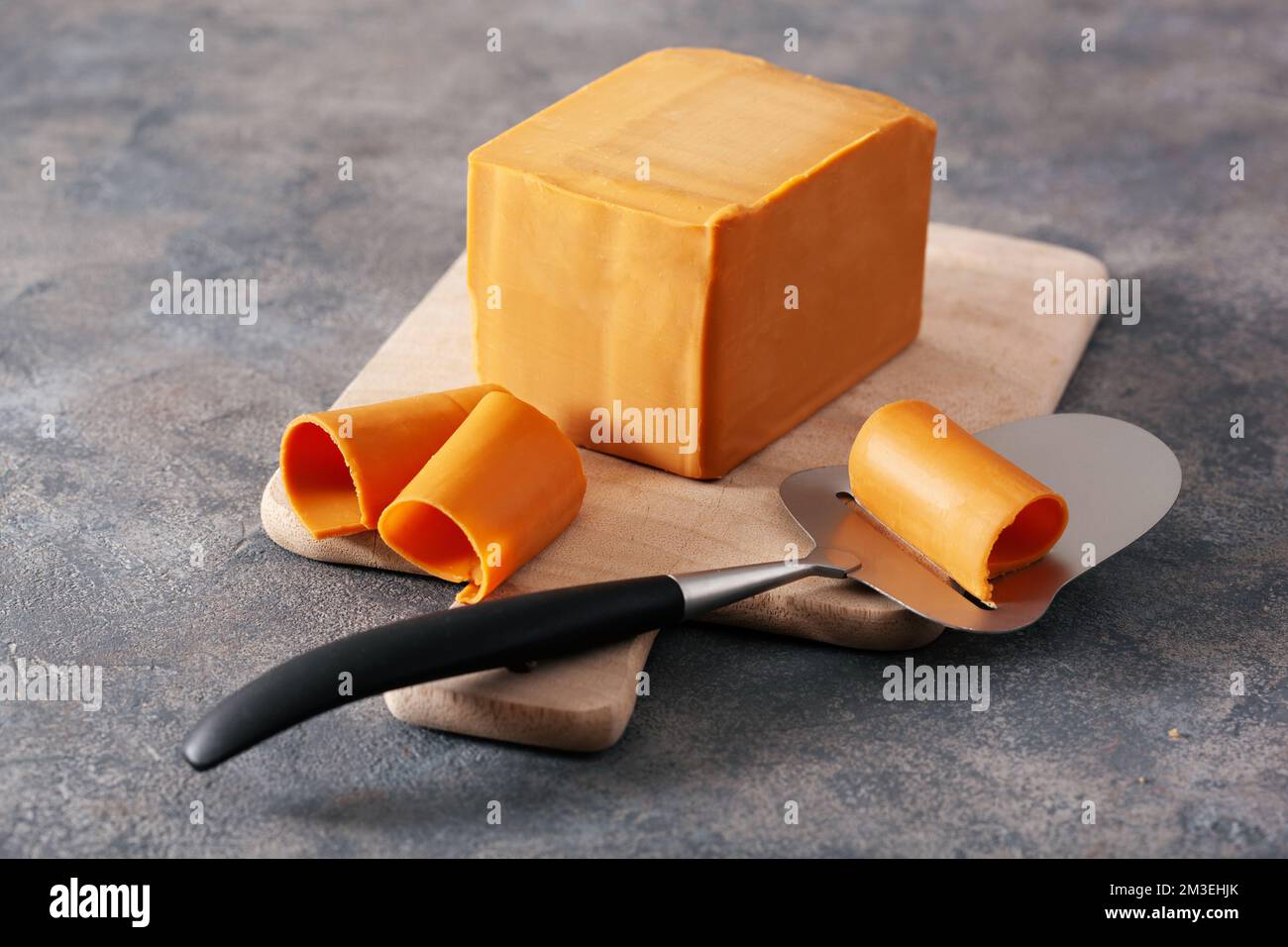 Norwegian brunost traditional brown cheese block and slicer Stock Photo ...