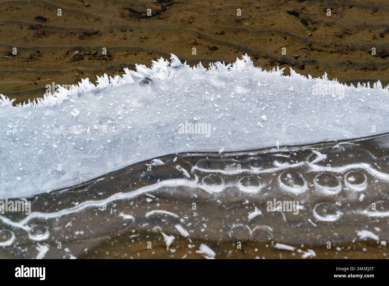 Lace patterns of the frozen water edge on the pond Stock Photo - Alamy