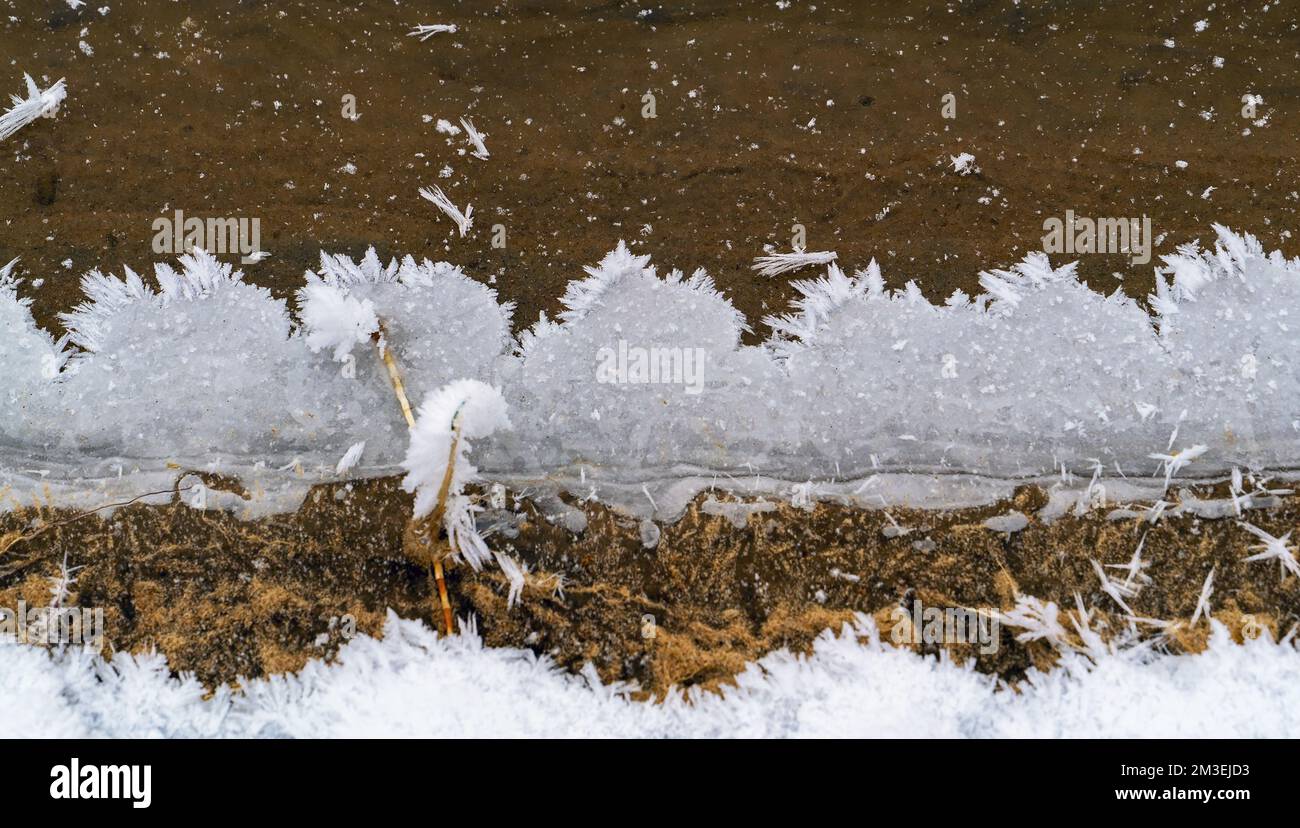Lace patterns of the frozen water edge on the pond Stock Photo - Alamy