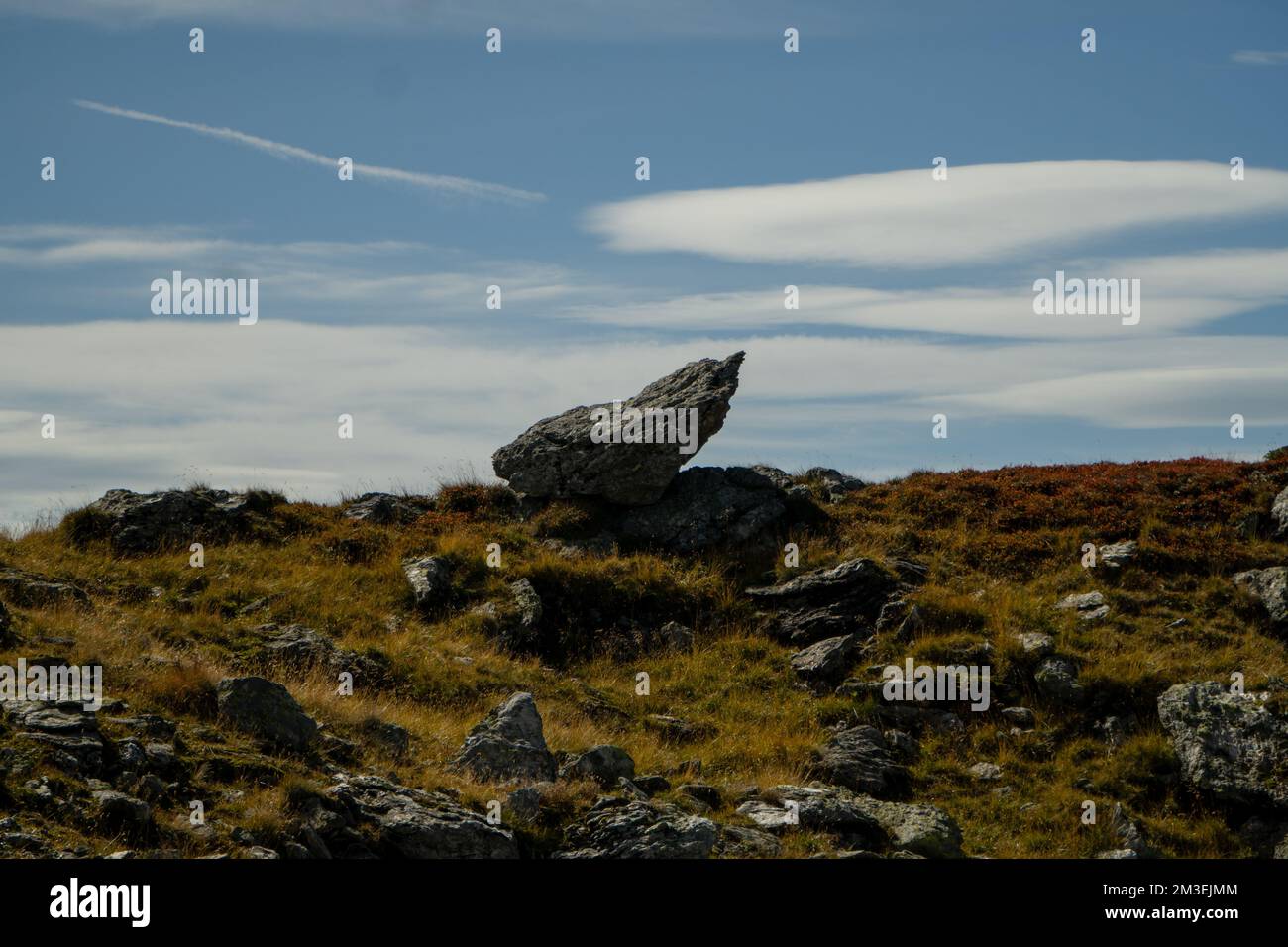 A beautiful scenery of a huge rock on a hill in cloudy sky background ...