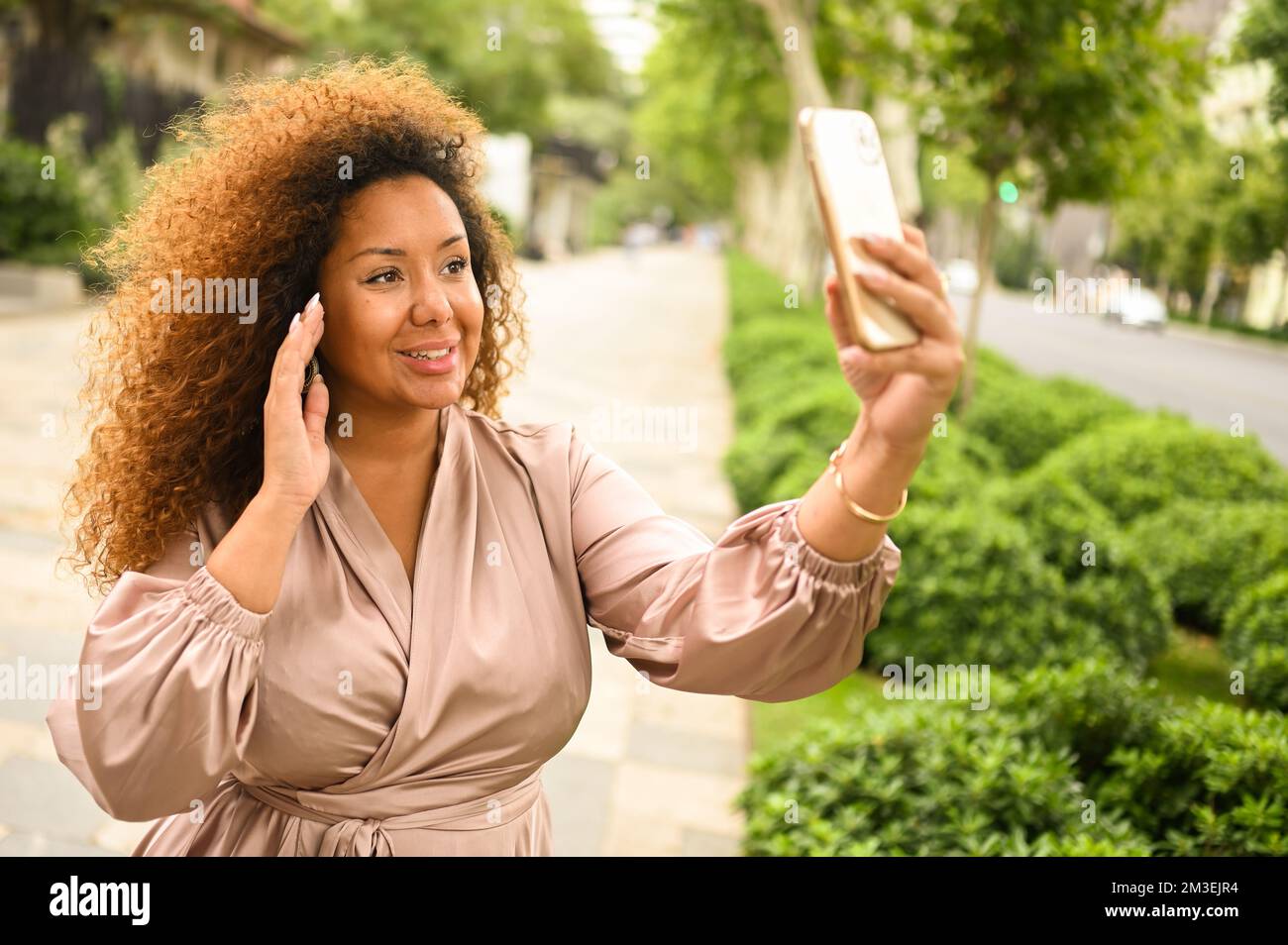 Attractive happy stylish plus size African American woman student freelancer afro hair making ...