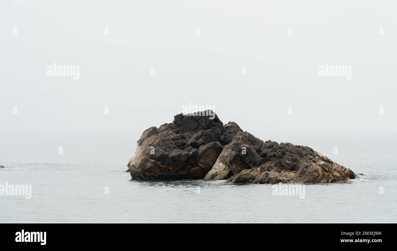 Stone block of rock in the water of the sea Stock Photo - Alamy