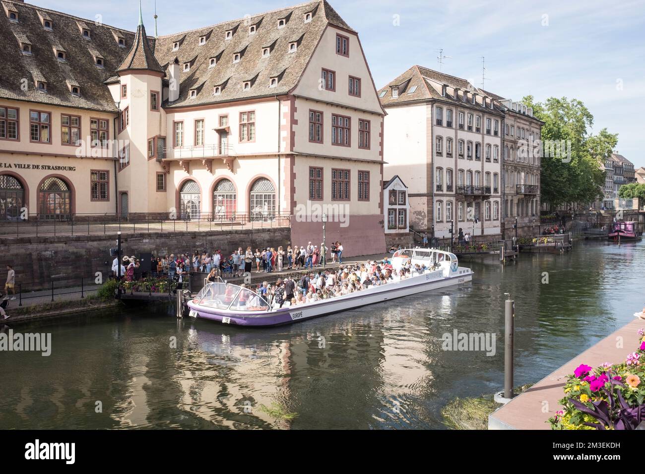 Tourists in a sightseeing boat at the old customs house on the Ill ...