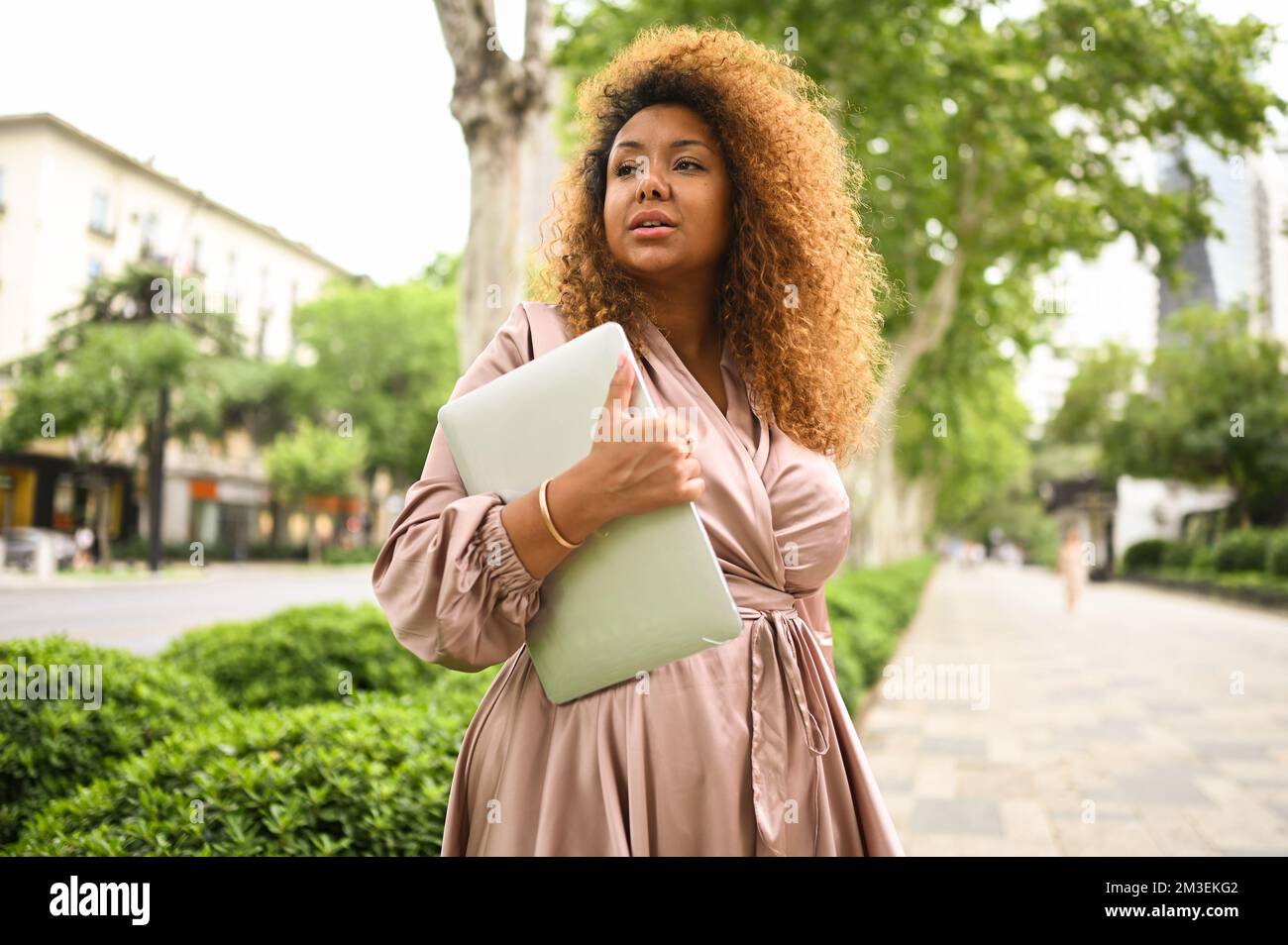 Attractive happy stylish plus size African American woman student freelancer afro hair with ...