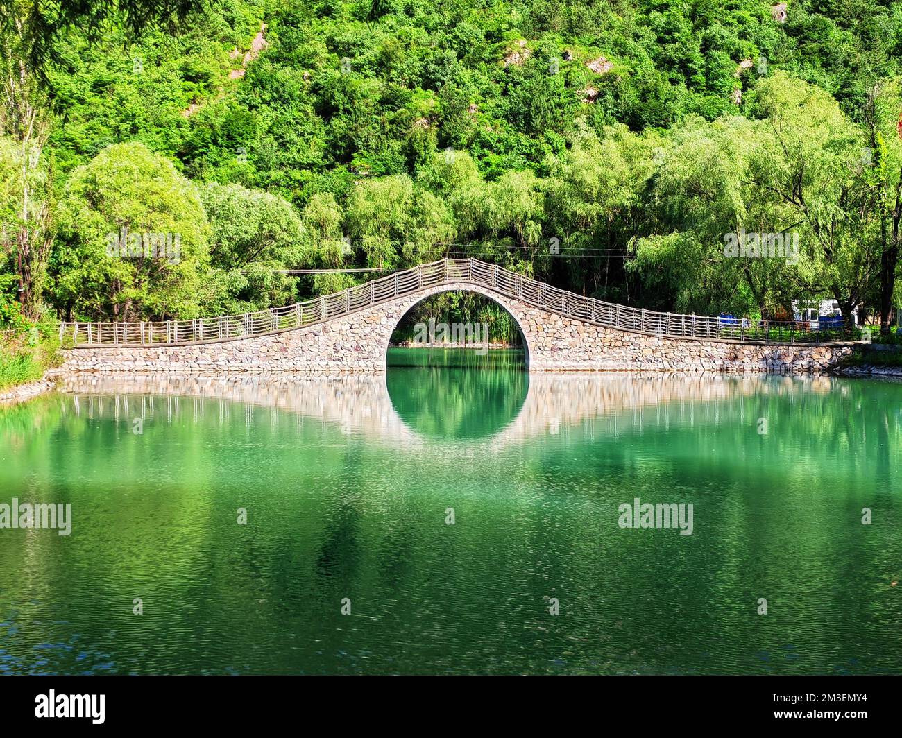 A reflection of an arch bridge in Hsinchu, Taiwan, green forest ...