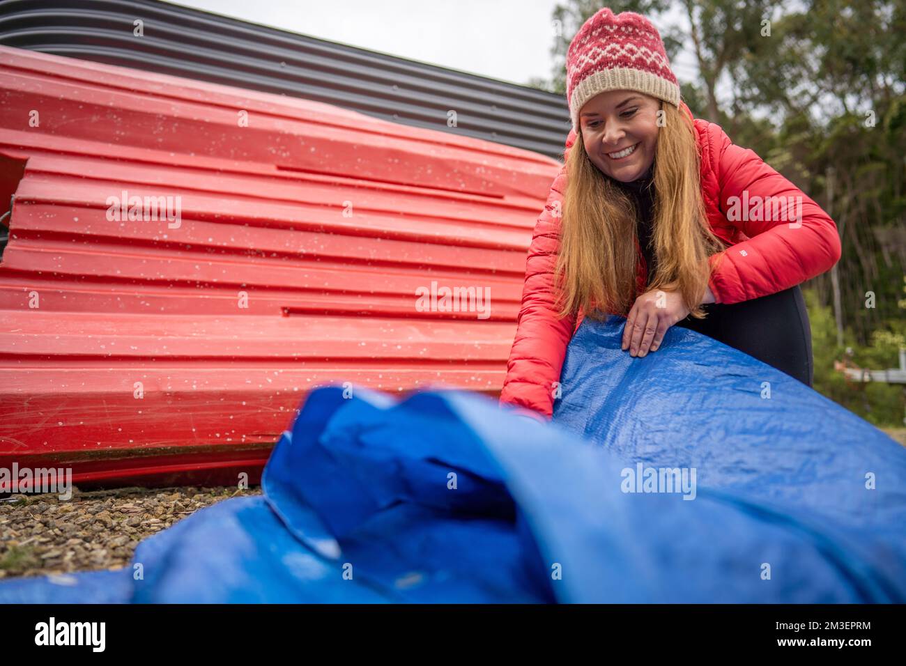 folding up a blue tarp after camping at a music festival in australia ...