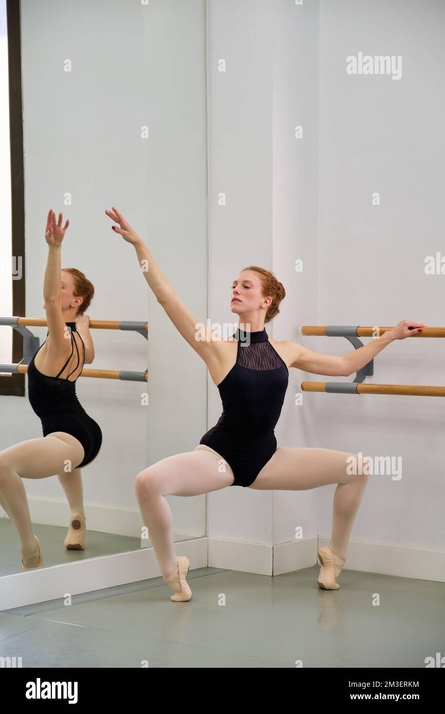 Young ballerina practicing ballet pose in a ballet school Stock Photo ...