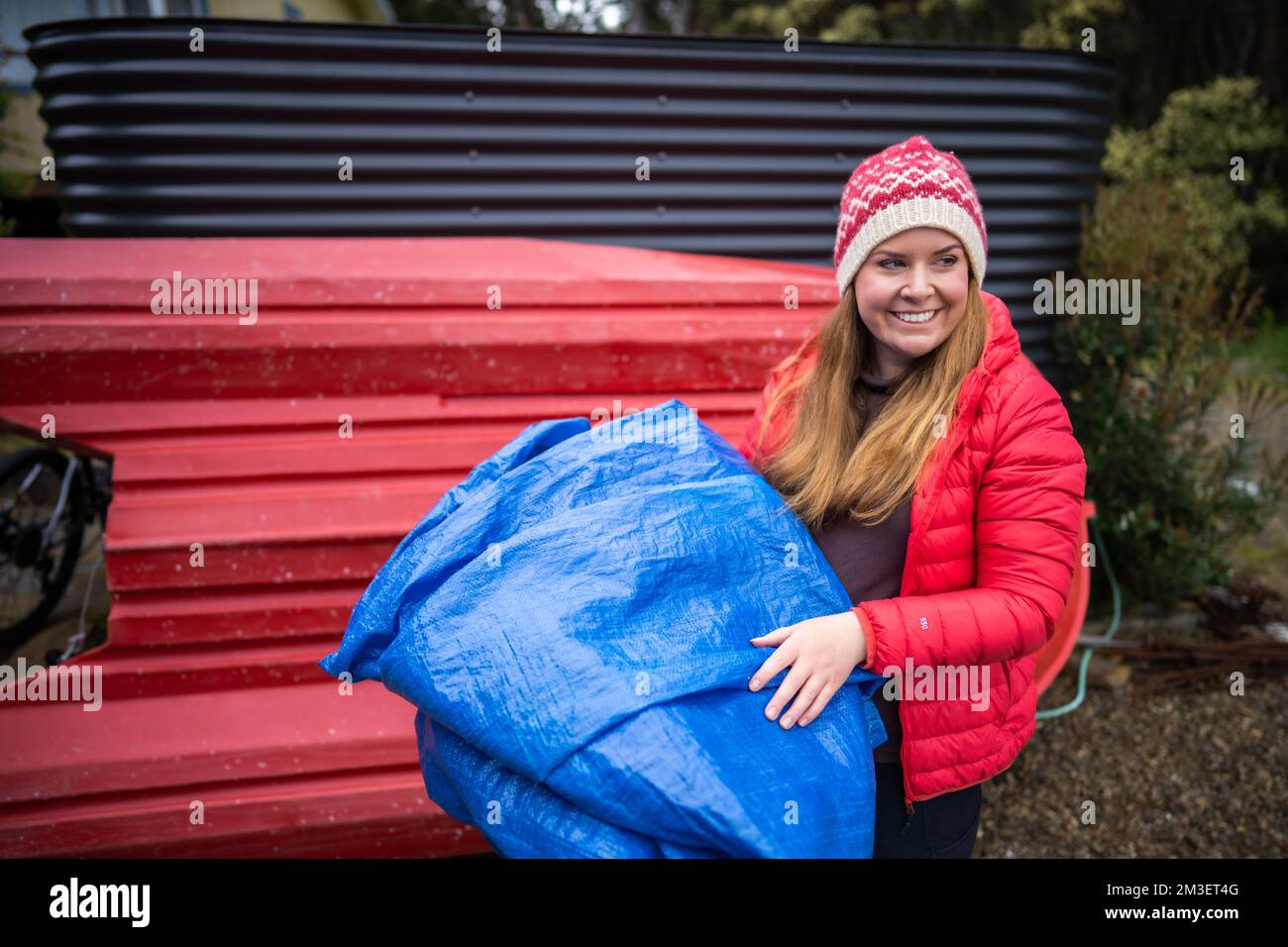 folding up a blue tarp after camping at a music festival in australia ...