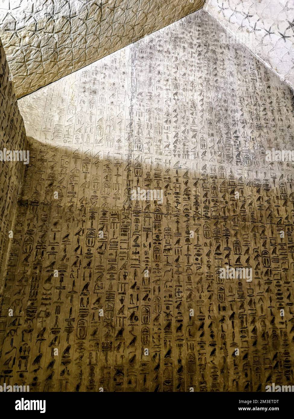 A vertical shot of the Pyramid Texts inscribed on the wall of a ...