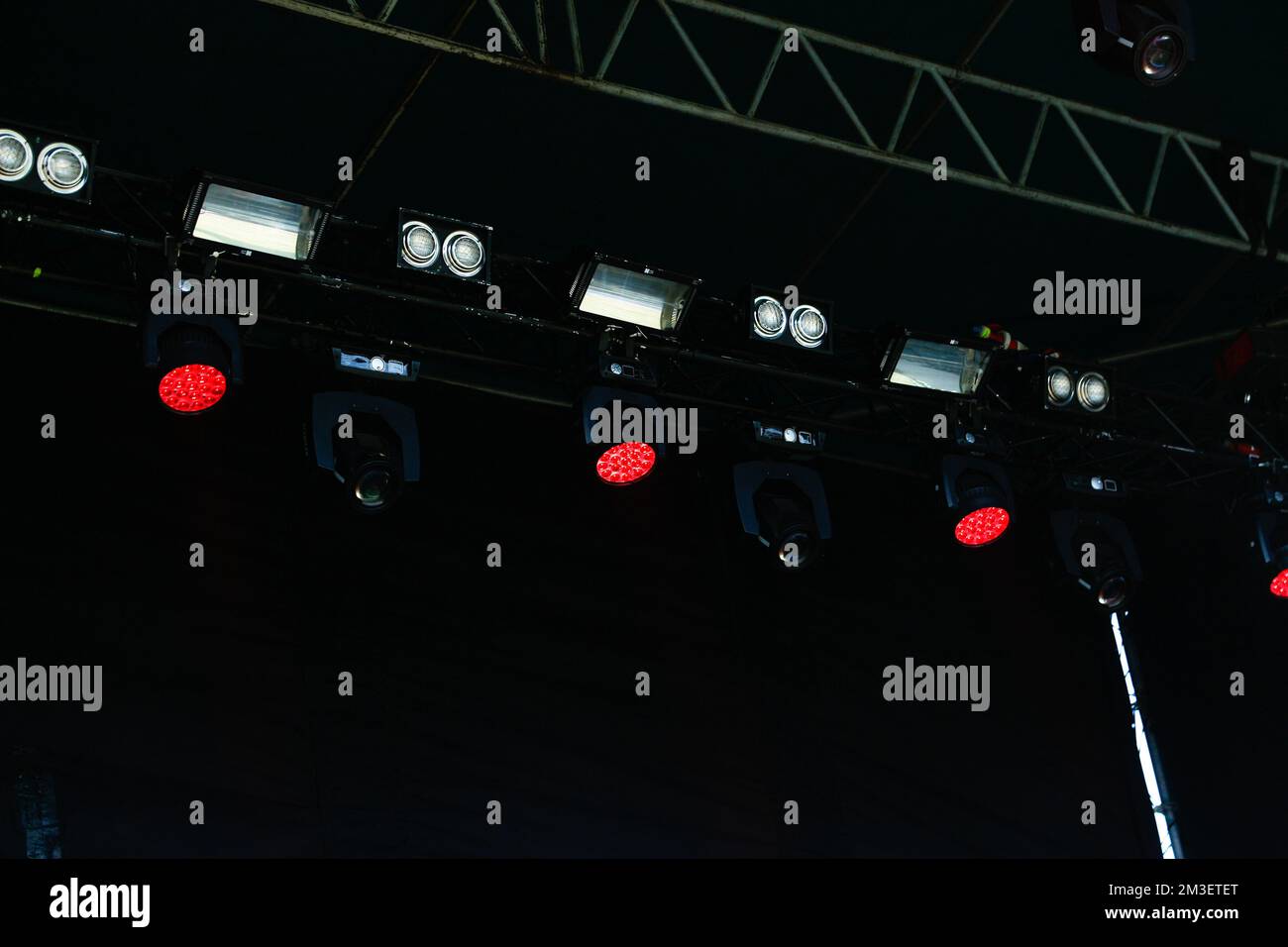 Defocus many red spotlights that illuminate the stage at a concert with ...