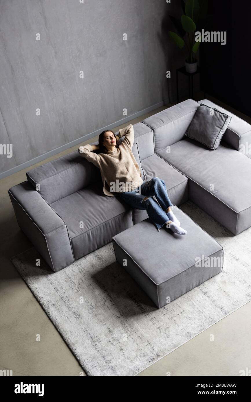 Full length peaceful woman with closed eyes resting on couch, leaning ...