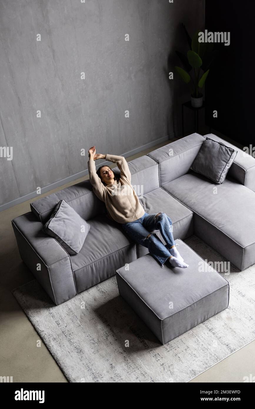 Full length peaceful woman with closed eyes resting on couch, leaning ...