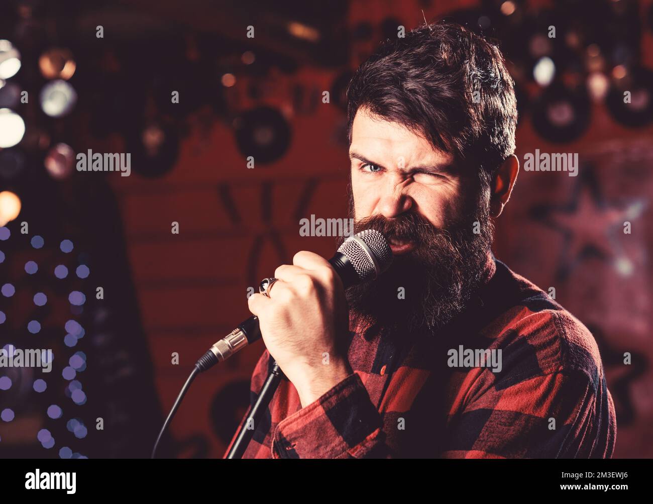 Musician with beard and mustache singing song in karaoke. Rock star ...