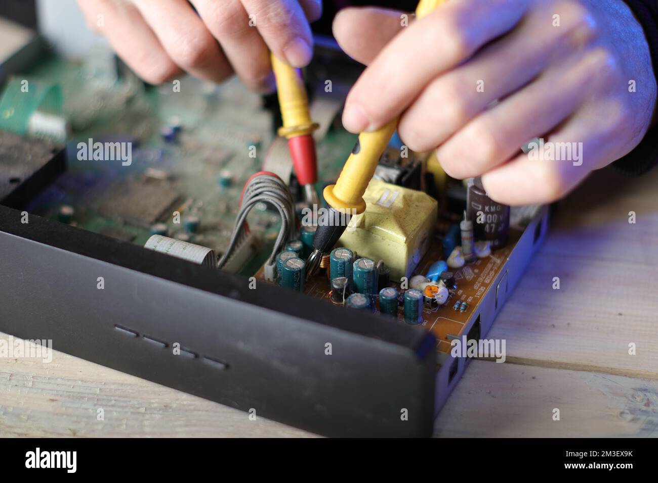 repair of an old satellite tuner by person on the table and gray ...