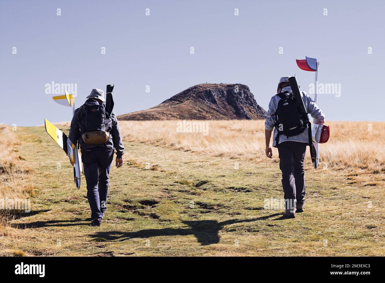 Men climb to the top of hill to launch a radio-controlled glider model ...