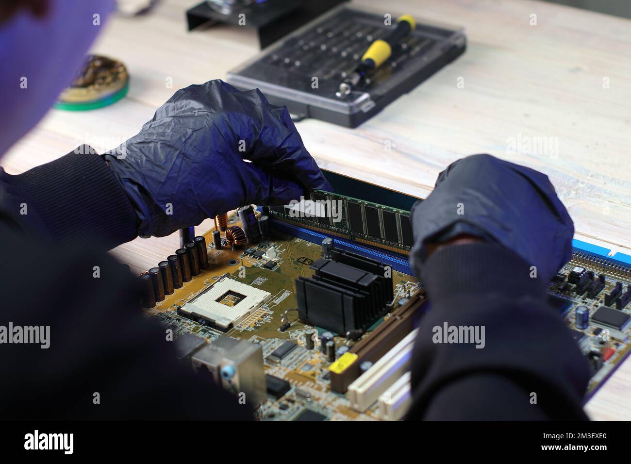 inserting ram into motherboard from computer on table and gray ...