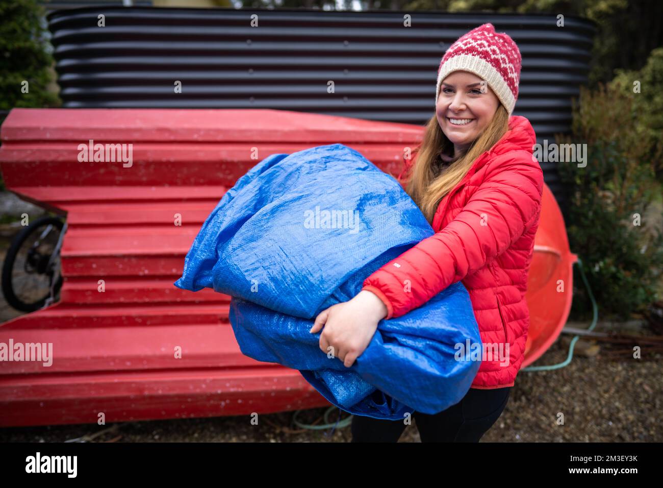 folding up a blue tarp after camping at a music festival in australia ...