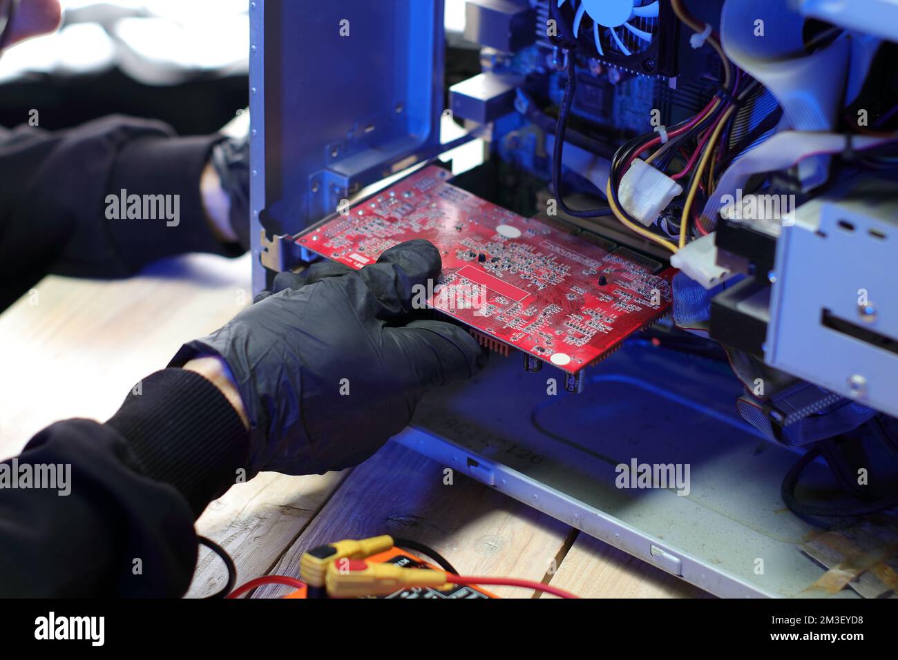 inserting an old graphics card into a computer on the table Stock Photo ...
