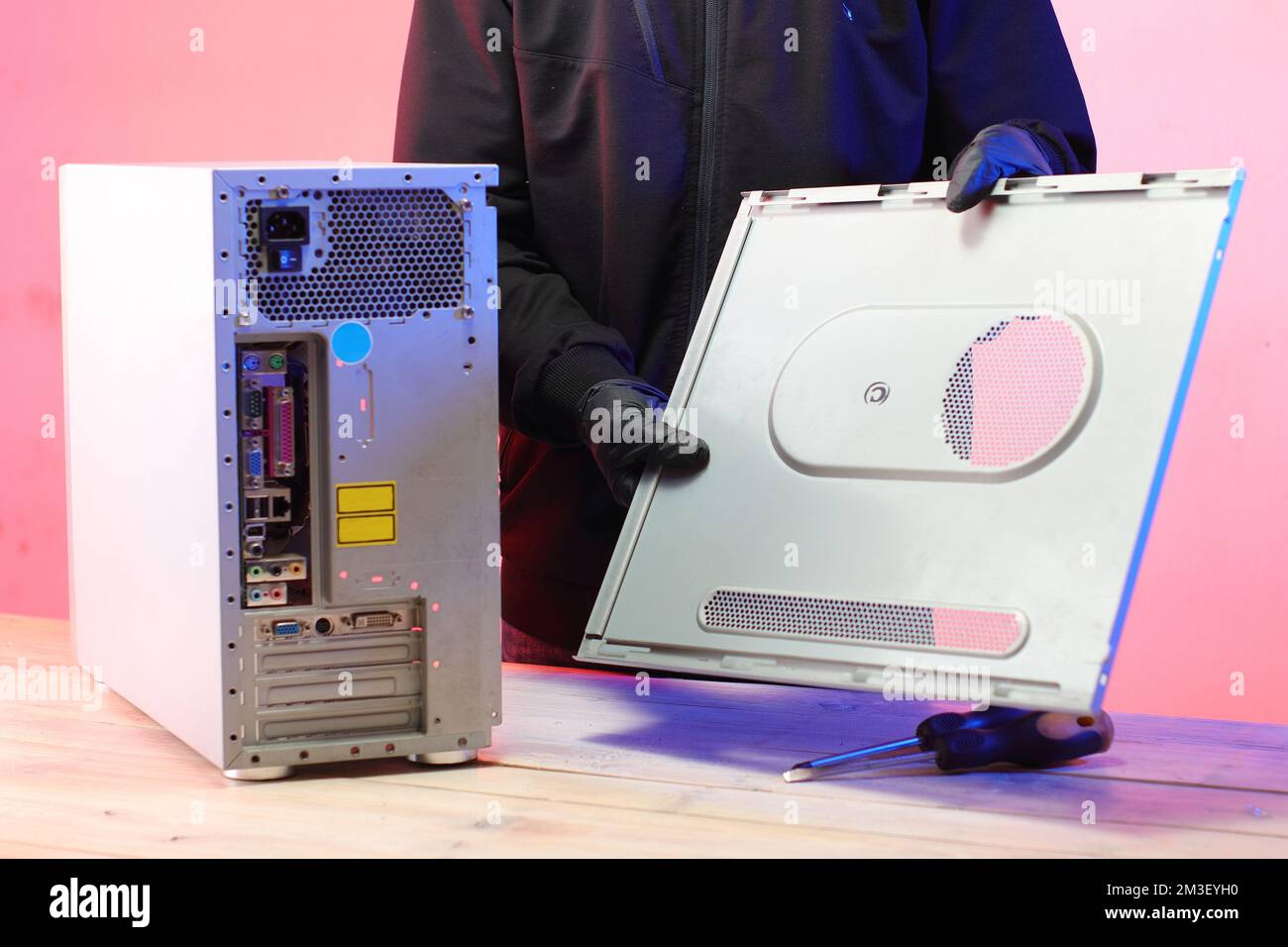 disassembly of an old desktop computer on a table and a pink background ...