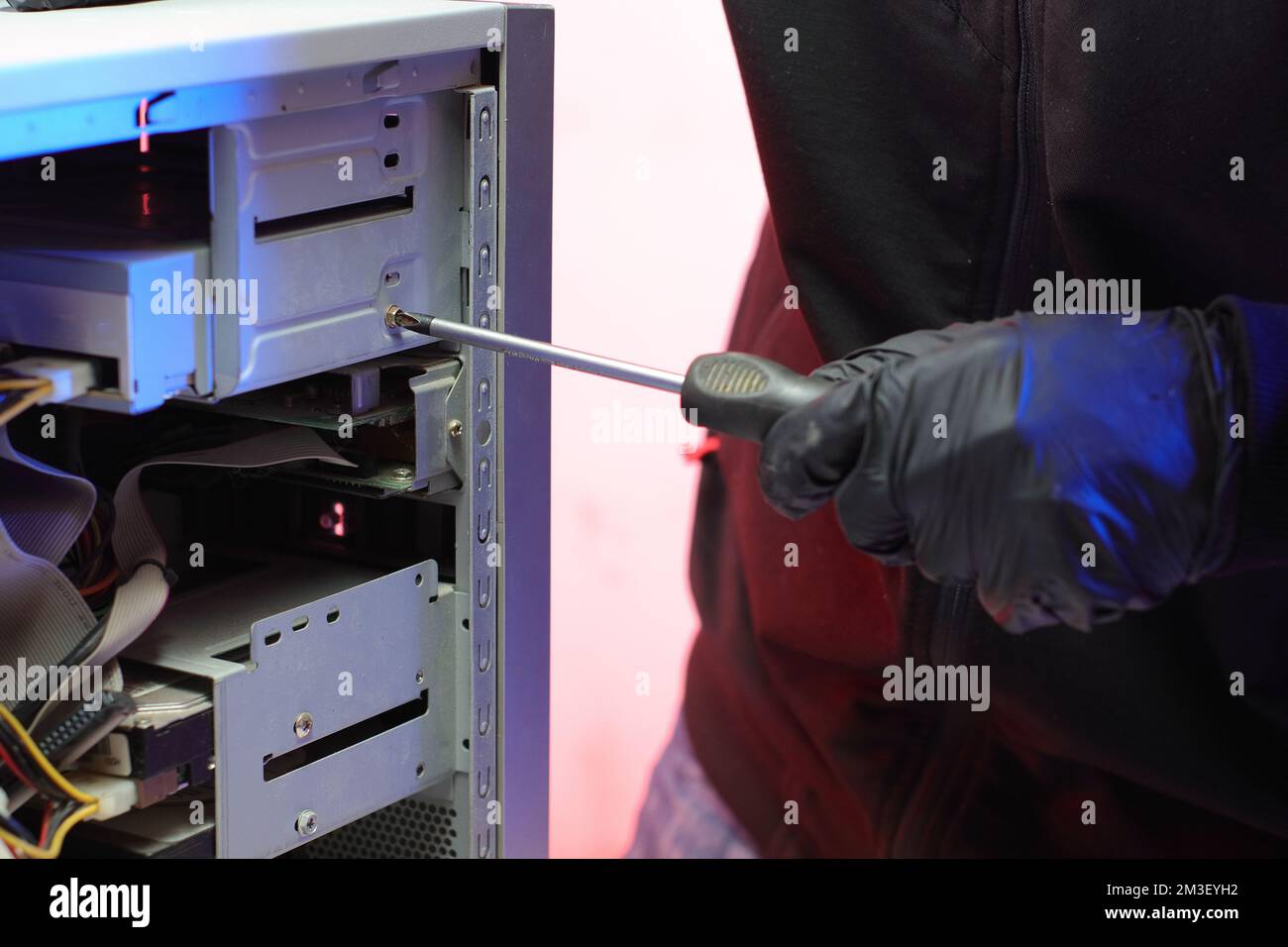 disassembly of an old desktop computer on a table and a pink background ...