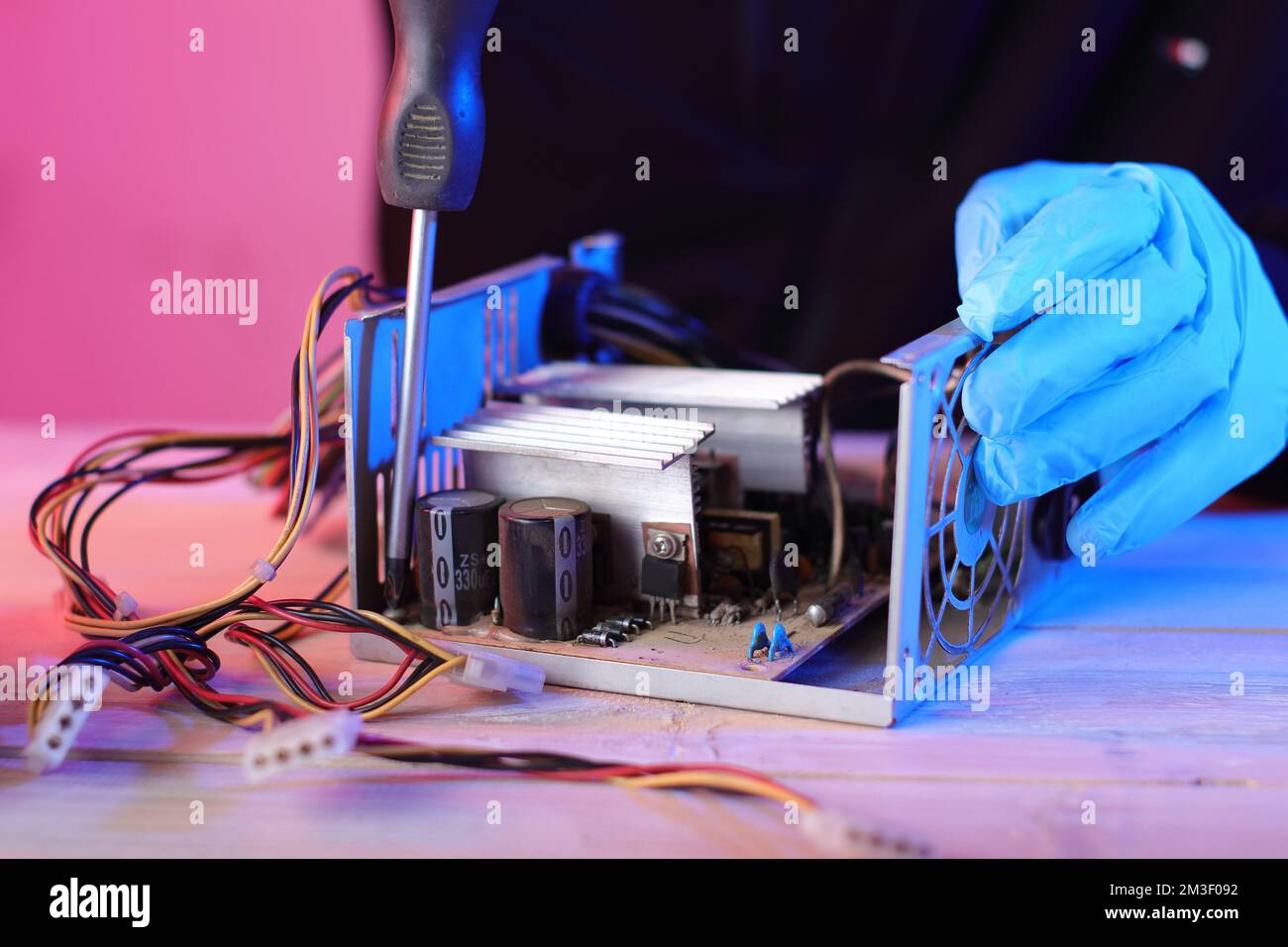 disassembly of a computer power supply on a table by a person and a ...