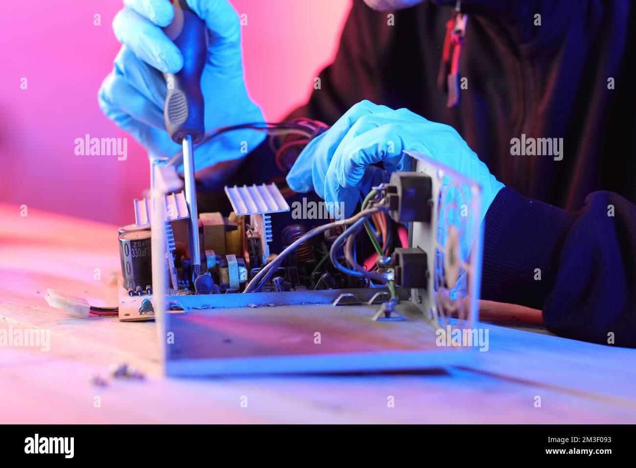 disassembly of a computer power supply on a table by a person and a ...