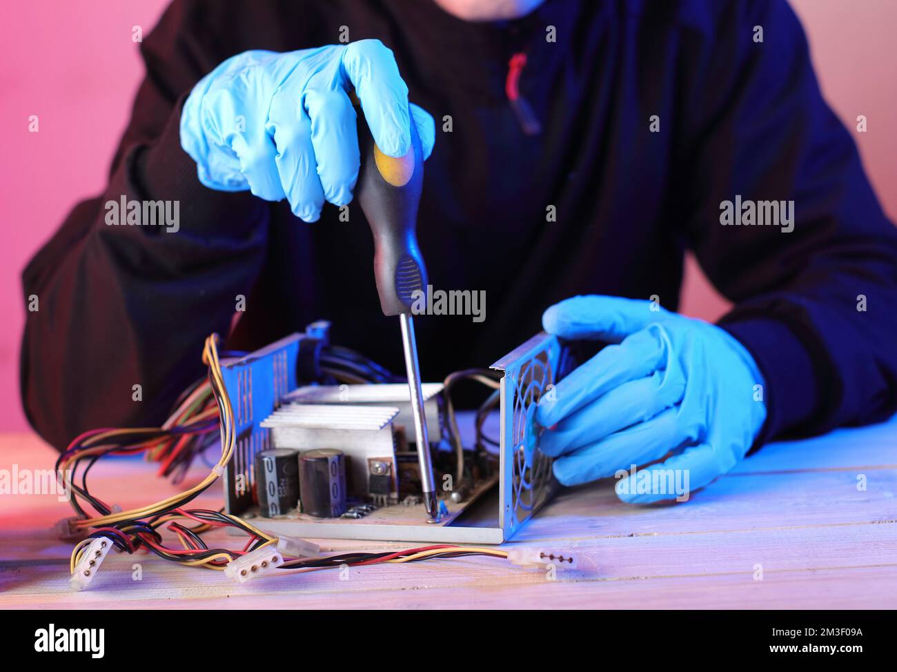 disassembly of a computer power supply on a table by a person and a ...