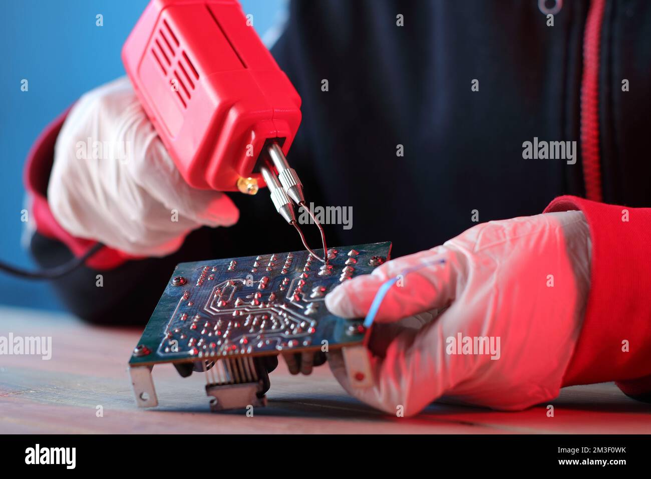 soldering on the board a red transformer soldering iron by a person on ...