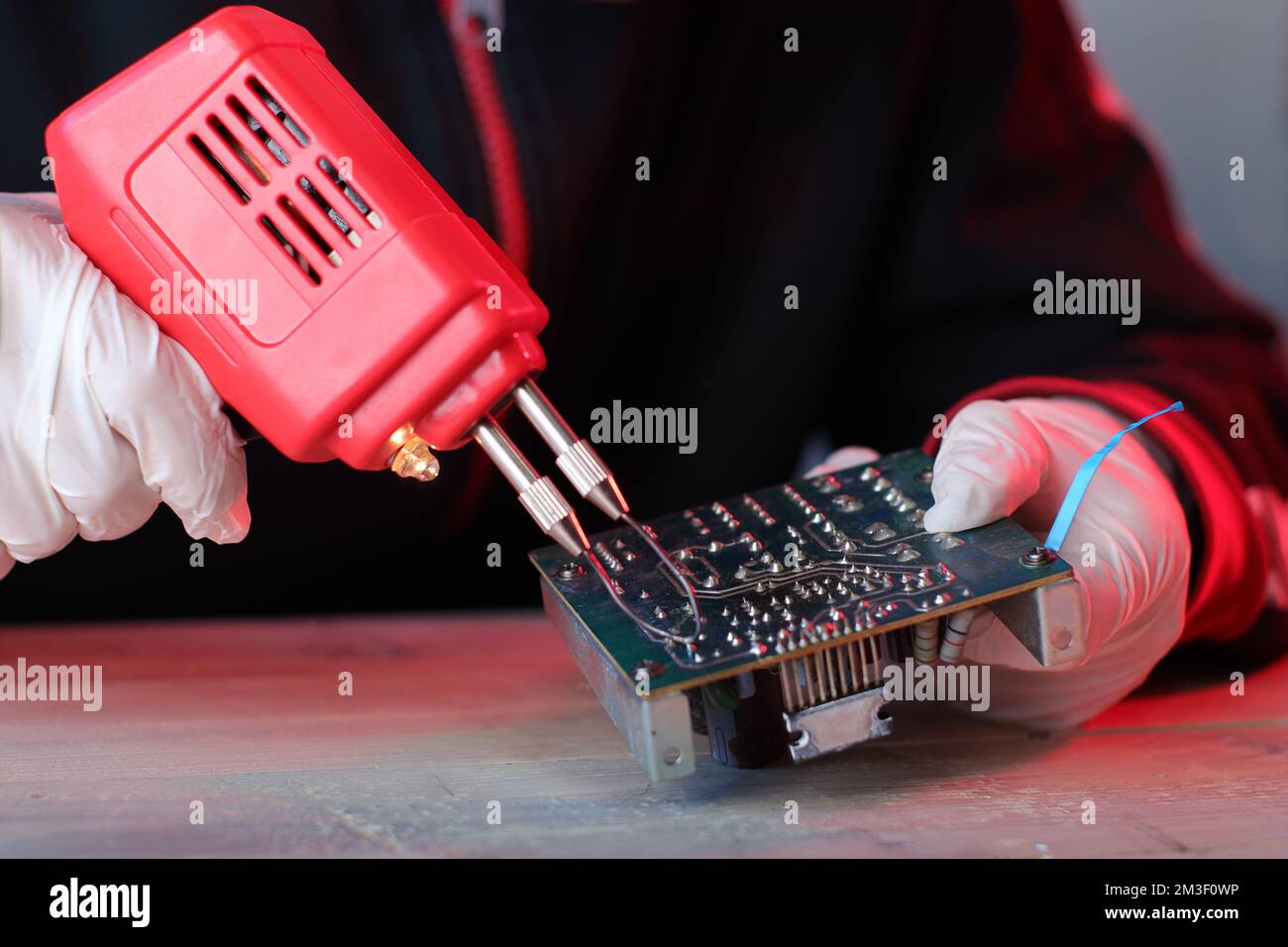 soldering on the board a red transformer soldering iron by a person on ...