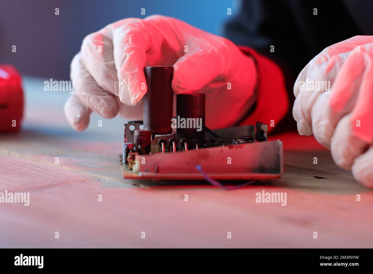 inserting a capacitor into a printed circuit board by a person on a ... inserting a capacitor into a printed circuit board by a person on a ...