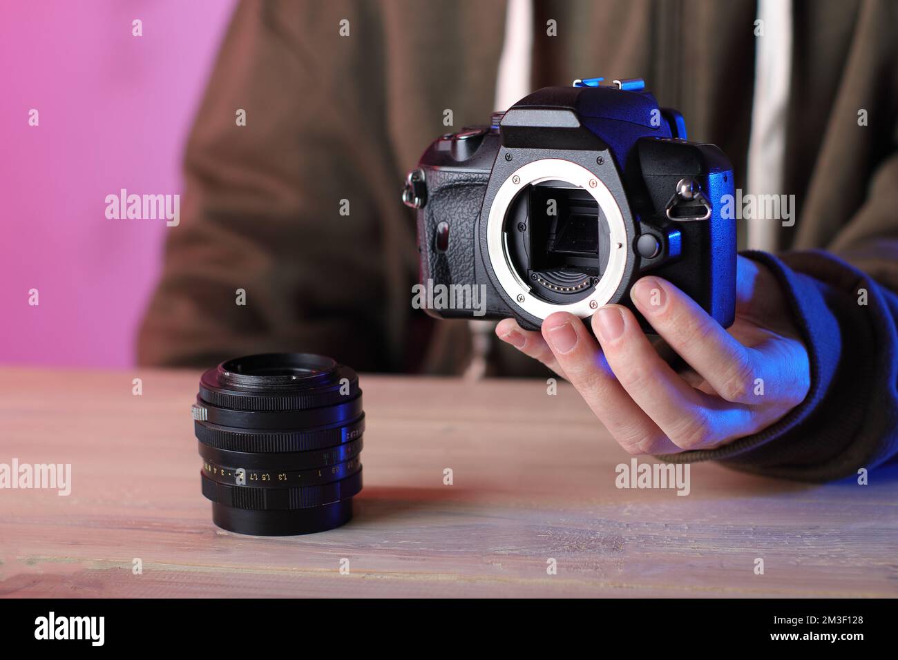 person taking the lens off the camera on a colored background Stock ...