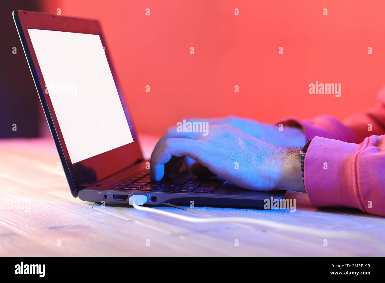 typing on laptop with usb cable and blank screen on table and colored ...