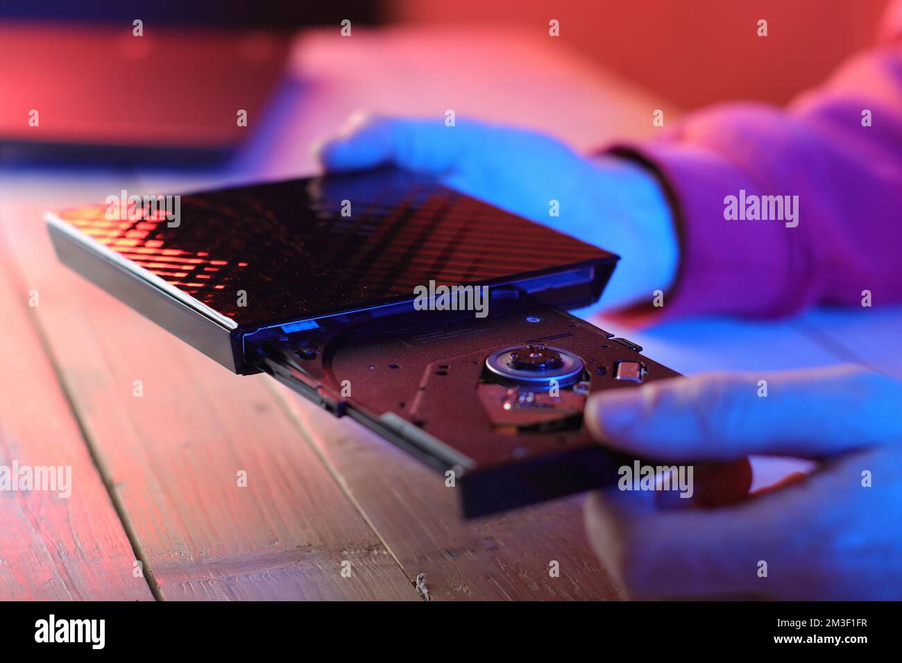 laptop optical drive with open tray on table and colored background ...